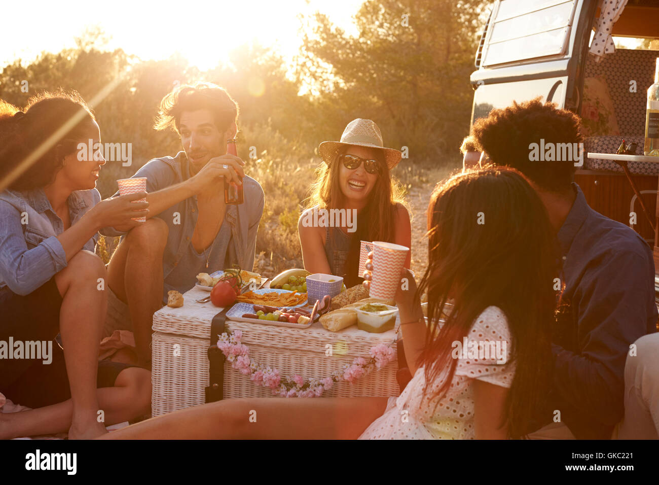Friends talking at a picnic beside their camper van Stock Photo - Alamy