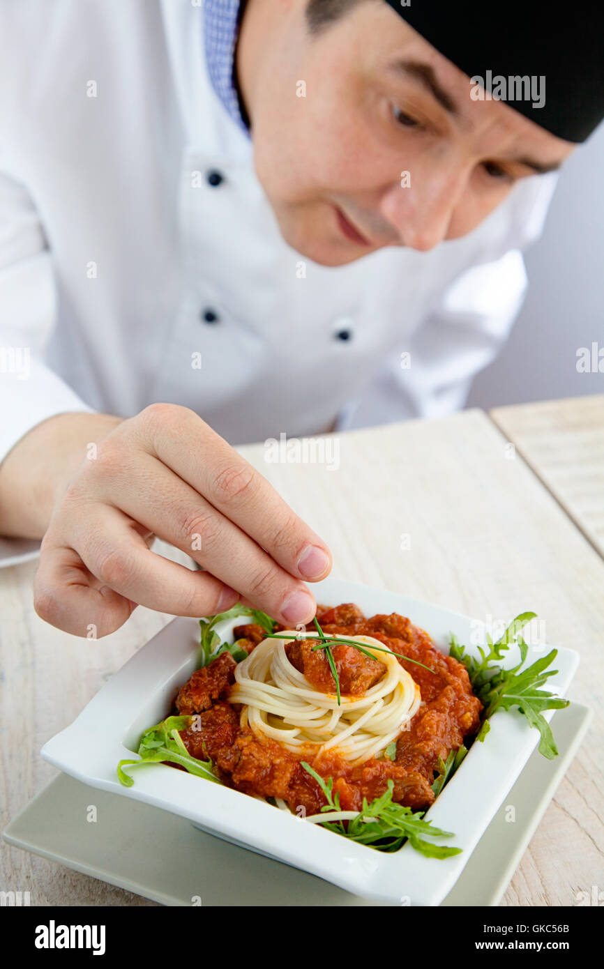 Smiling employee cooking pasta hi-res stock photography and images - Alamy
