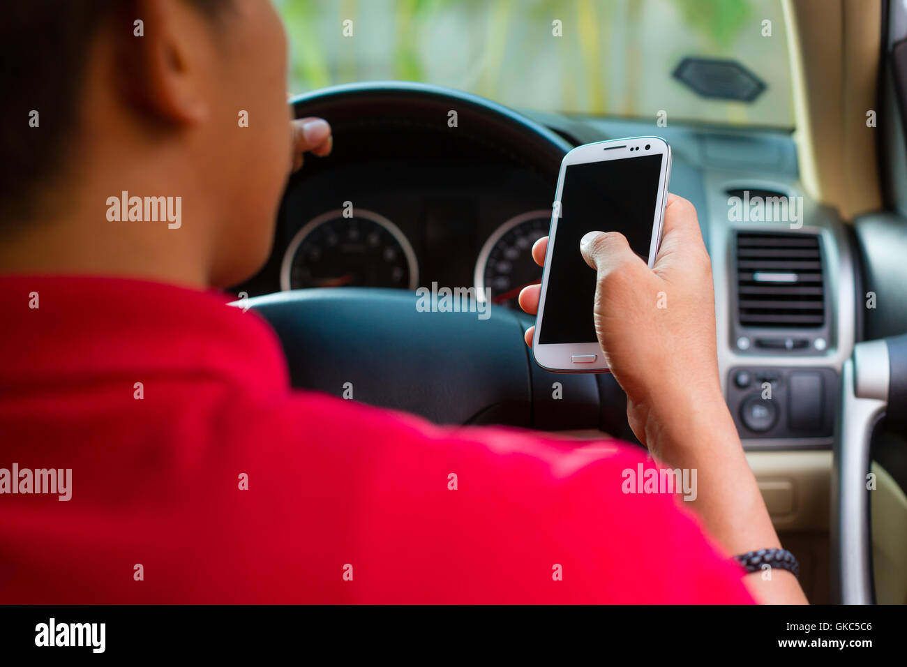 asian man writing sms while driving Stock Photo - Alamy