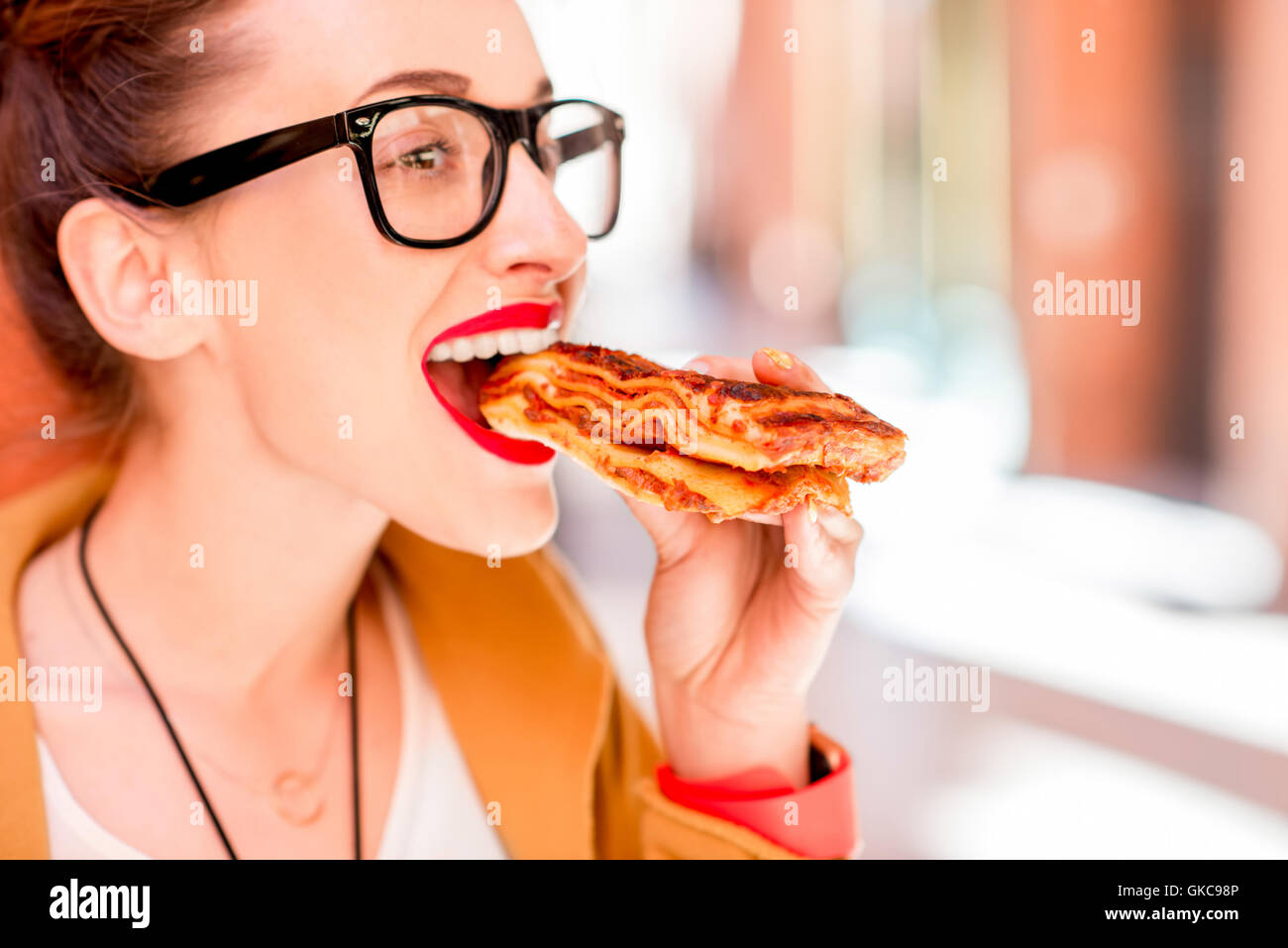 Woman eating lasagna outdoors Stock Photo - Alamy