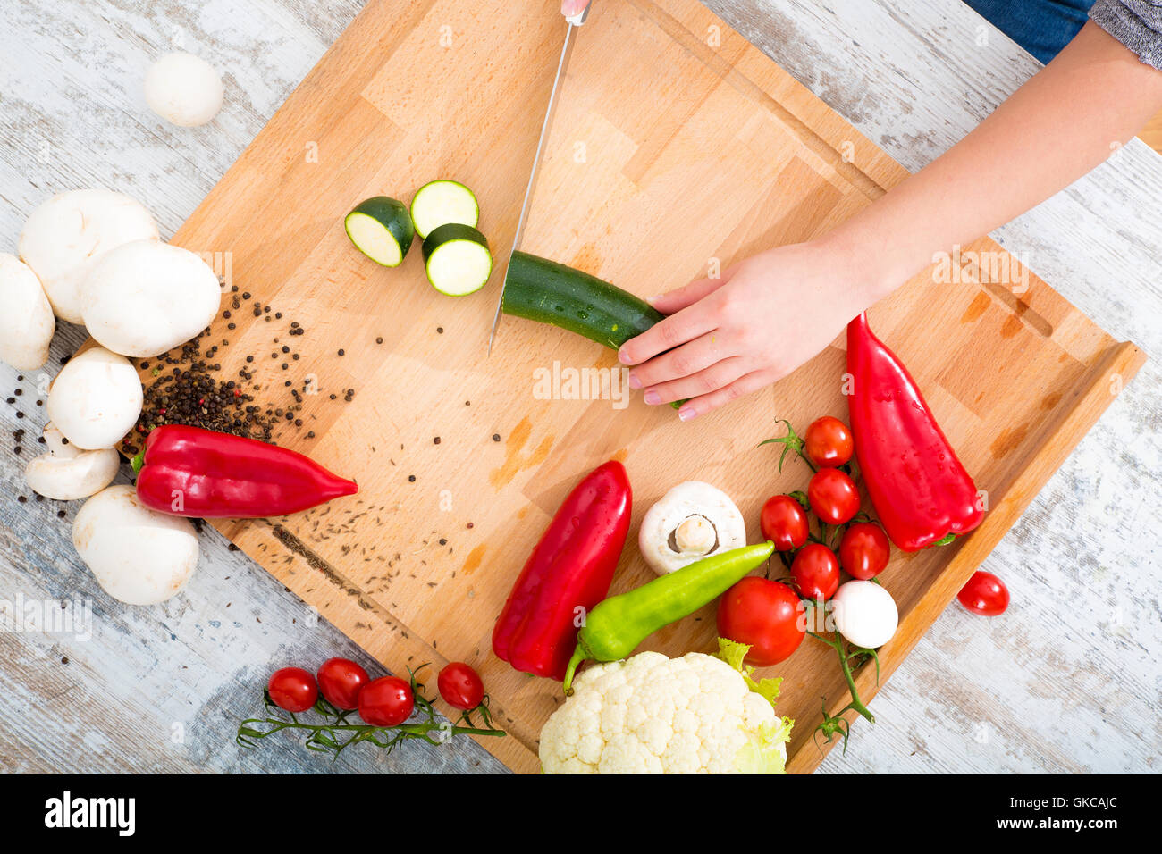 A woman chopping up vegetables at a table Stock Photo - Alamy