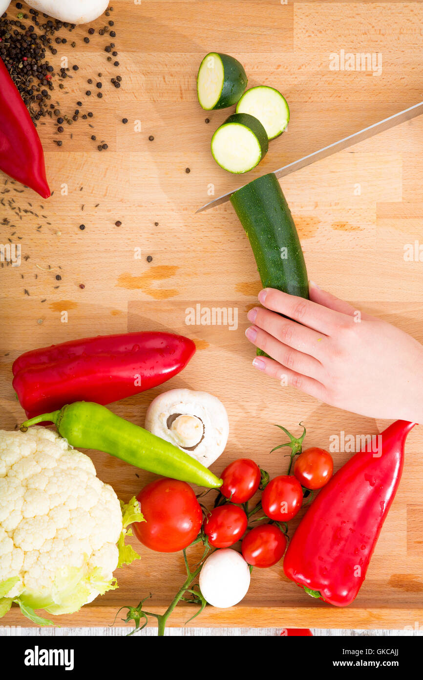A woman chopping up vegetables at a table Stock Photo - Alamy