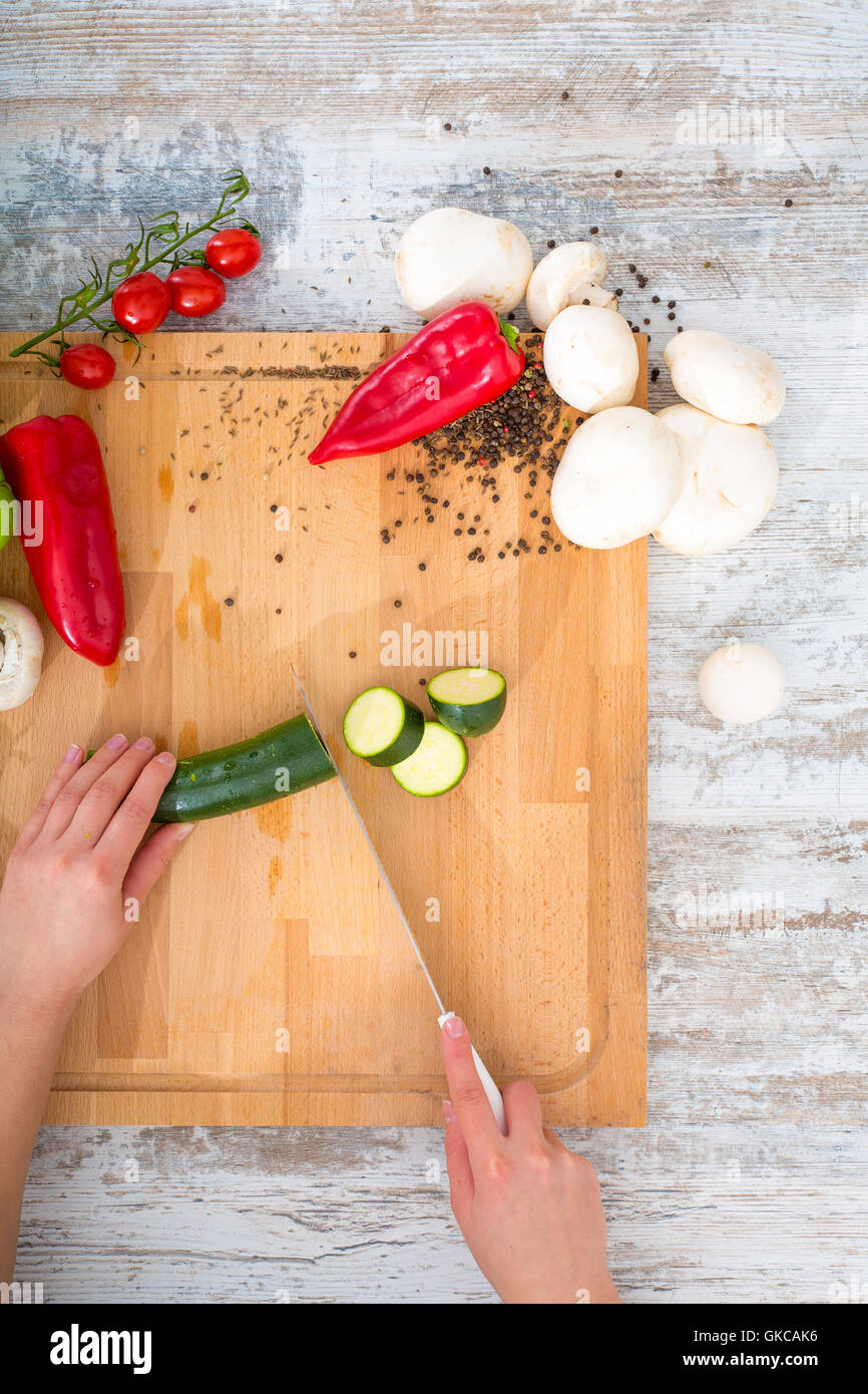 A woman chopping up vegetables at a table Stock Photo - Alamy