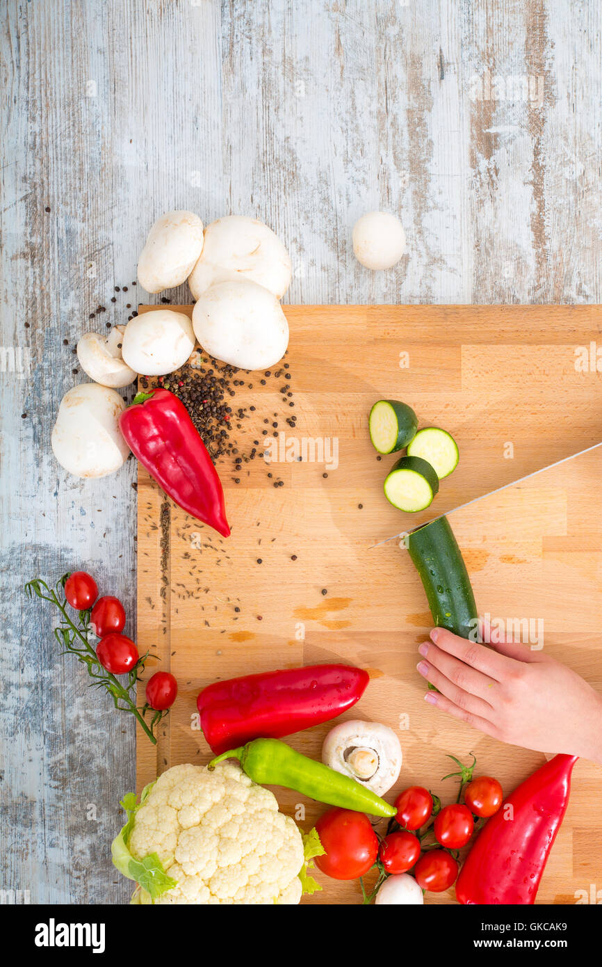 A woman chopping up vegetables at a table Stock Photo - Alamy