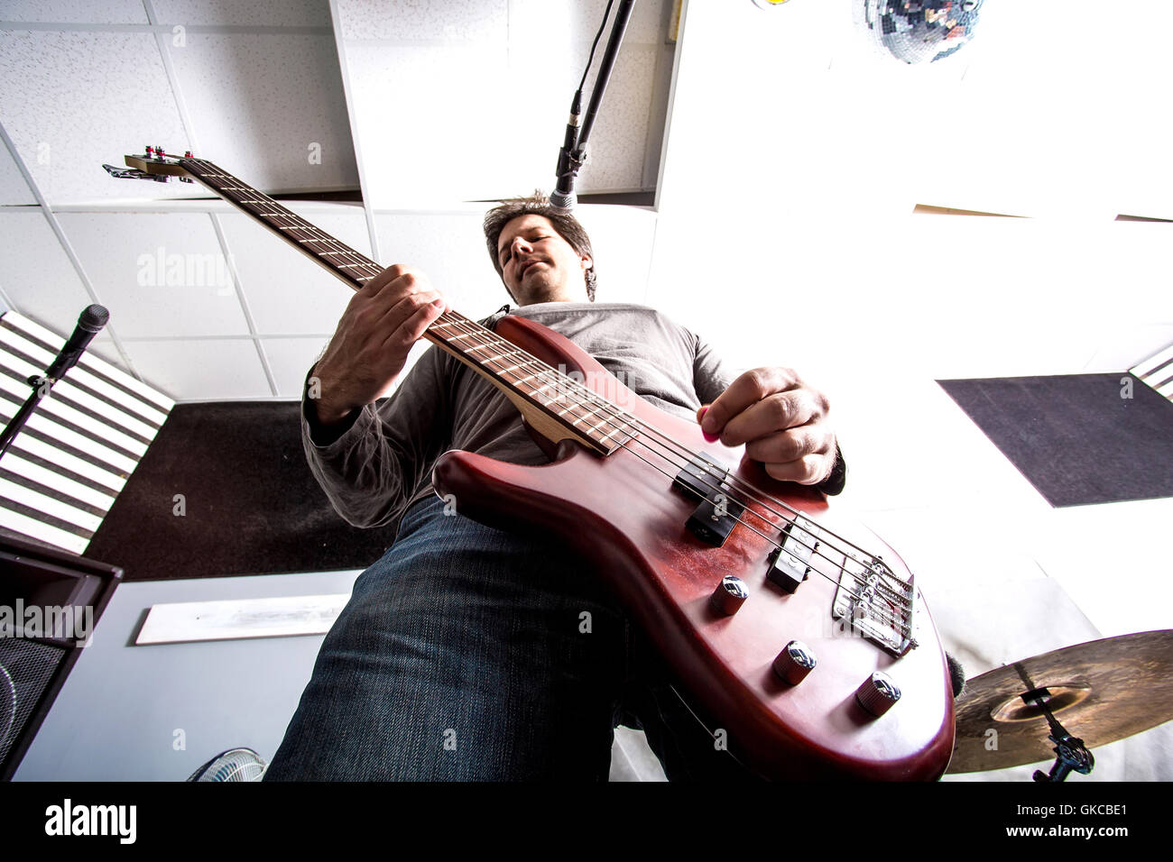 A Rock musician playing passionately bass in the rehearsal Studio Stock ...
