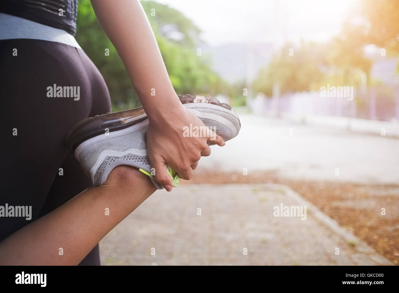 Close up side view of fitness woman runner stretching legs before run ...