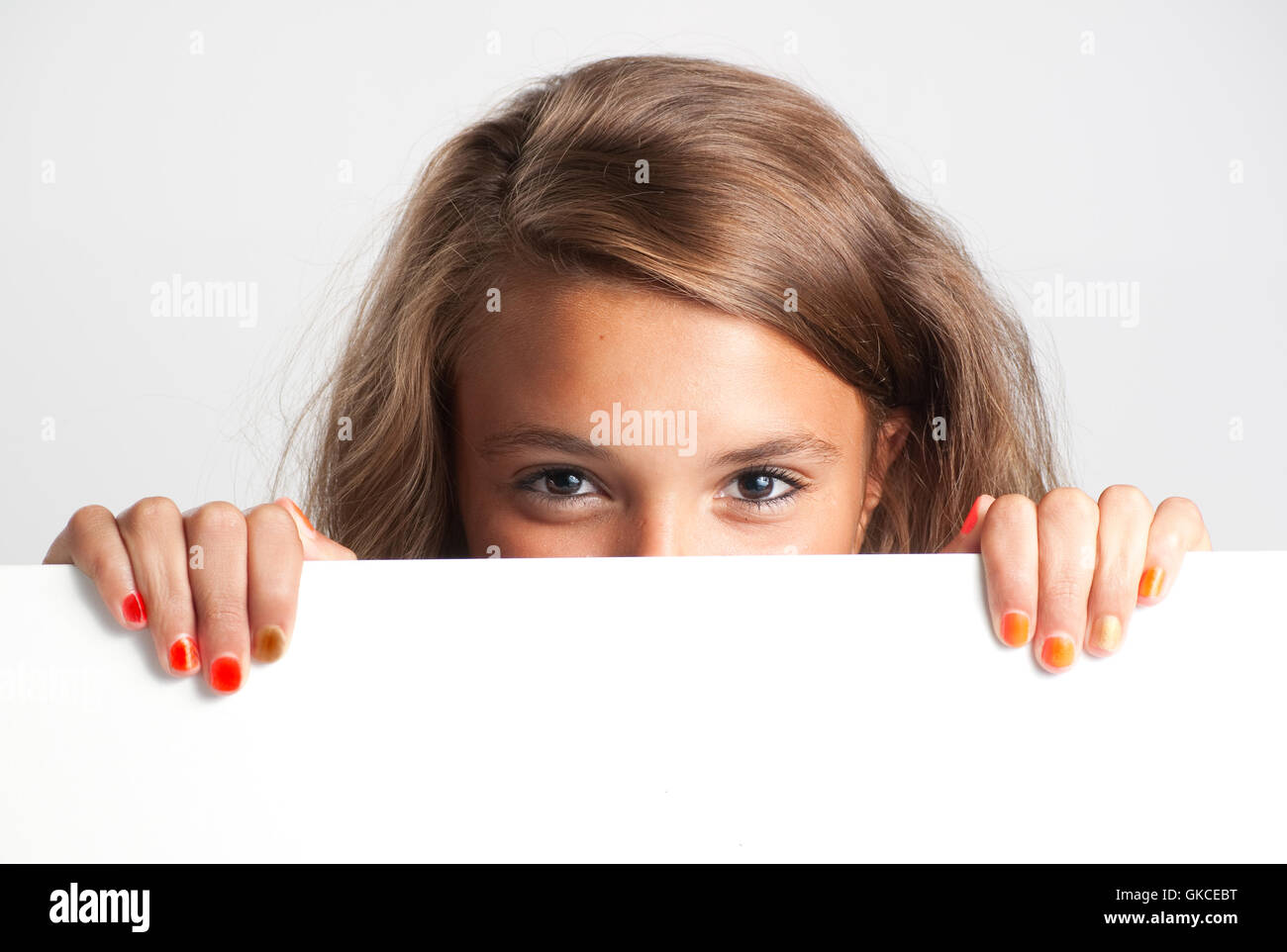 Young girl peaking over white board Stock Photo - Alamy