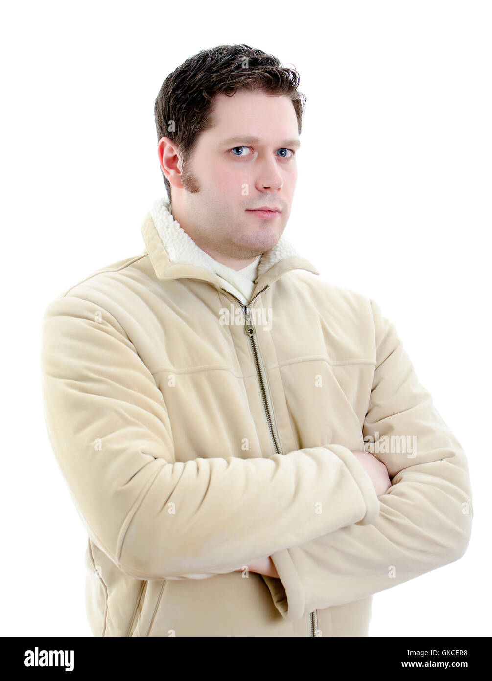 Portrait of a handsome young man in winter coat with arms crossed ...