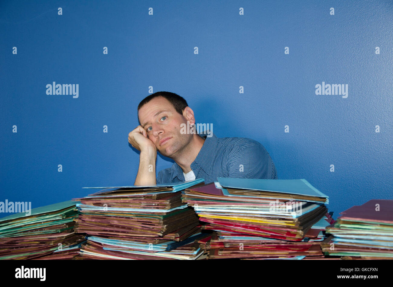 Man bored at work resting his head on his fist Stock Photo - Alamy