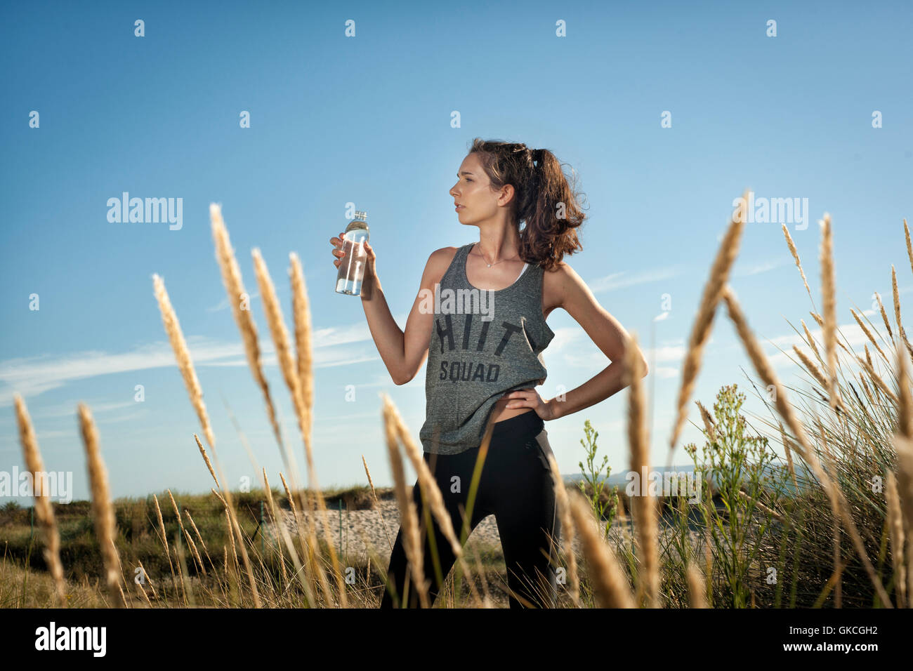 fit woman with a bottle of water while exercising outside Stock Photo ...