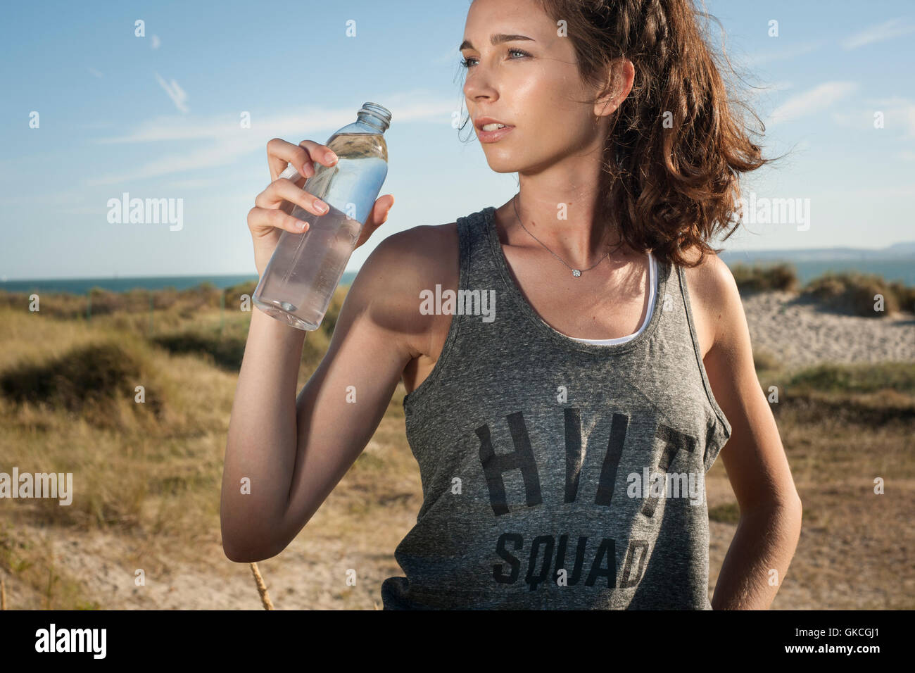 fit woman with a bottle of water while exercising outside Stock Photo ...