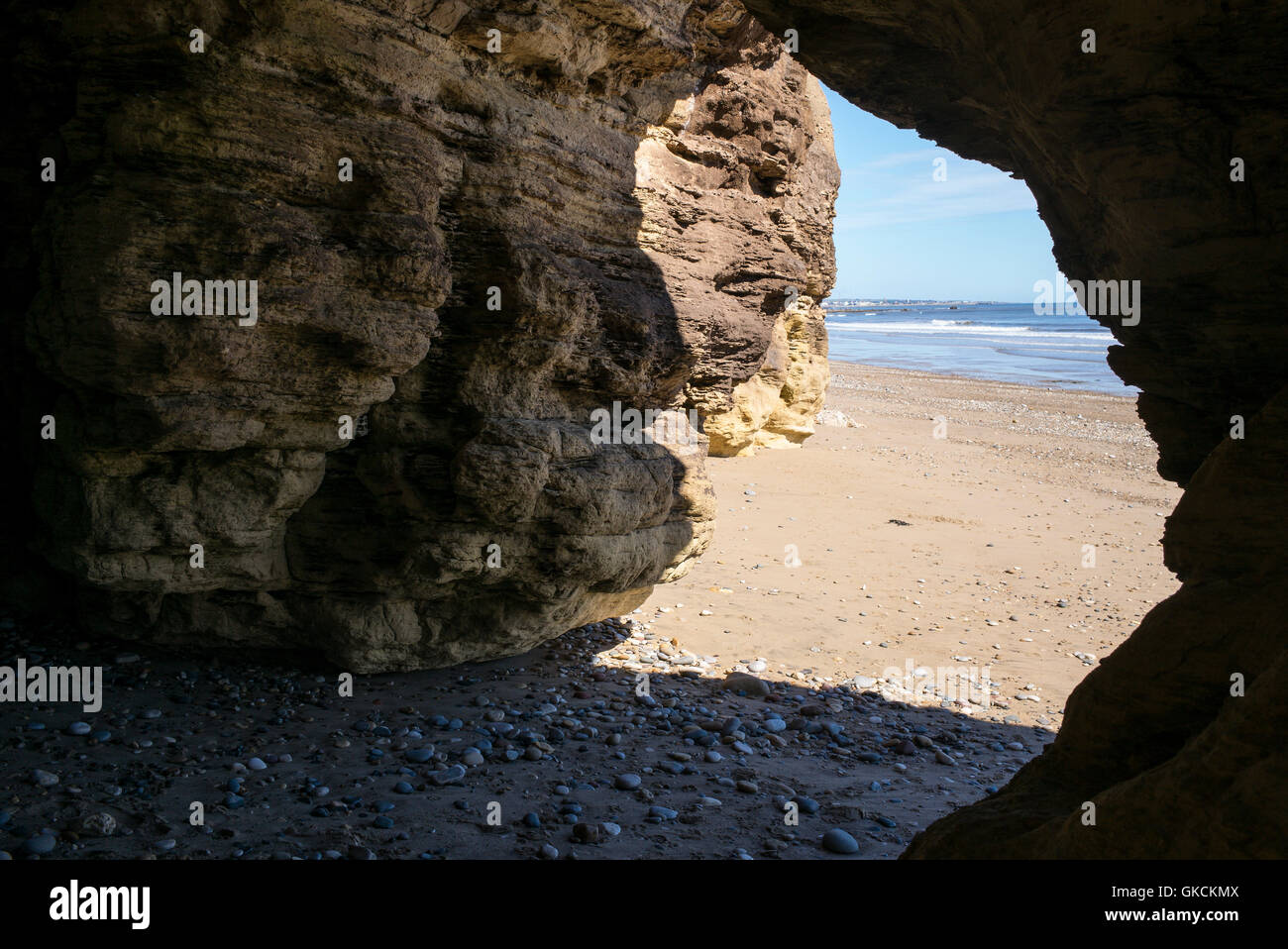 Caves eroded from cliffs of yellow coloured Magnesian Limestone rock at ...