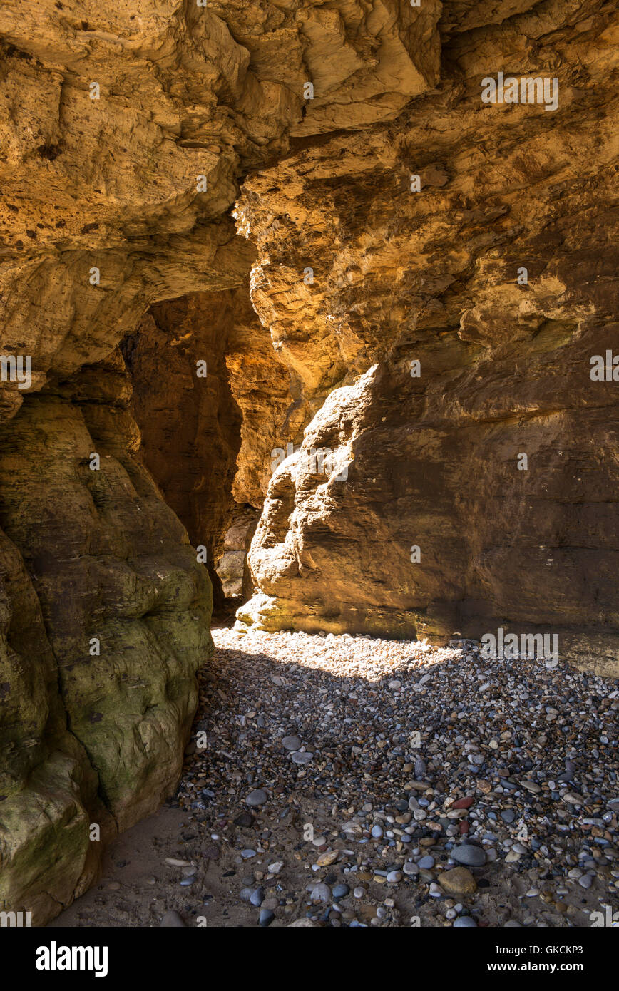 Caves eroded from cliffs of yellow coloured Magnesian Limestone rock at ...