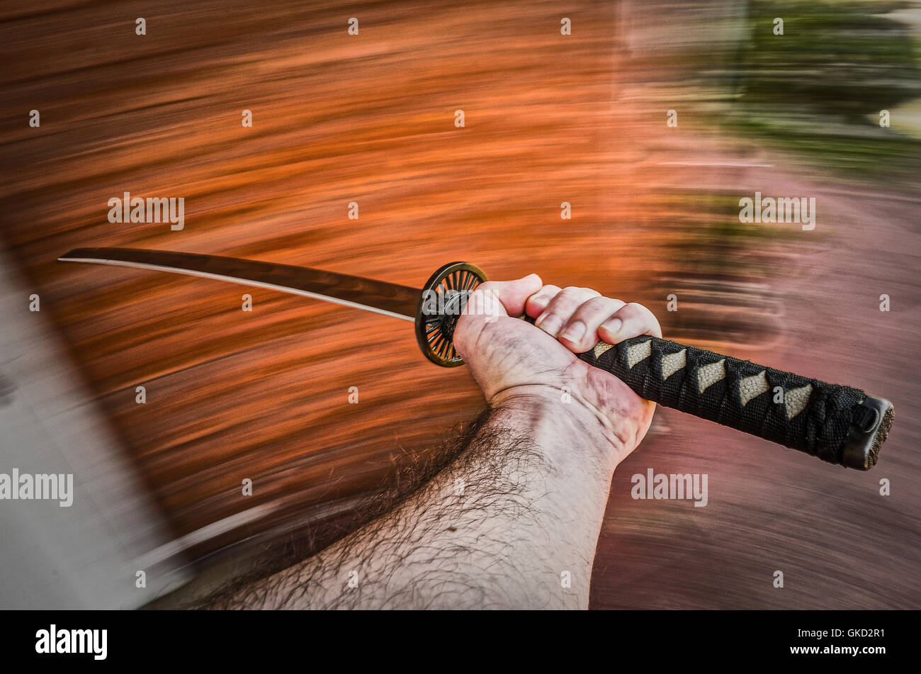 A hand brandishing an ornamental japanese sword Stock Photo - Alamy
