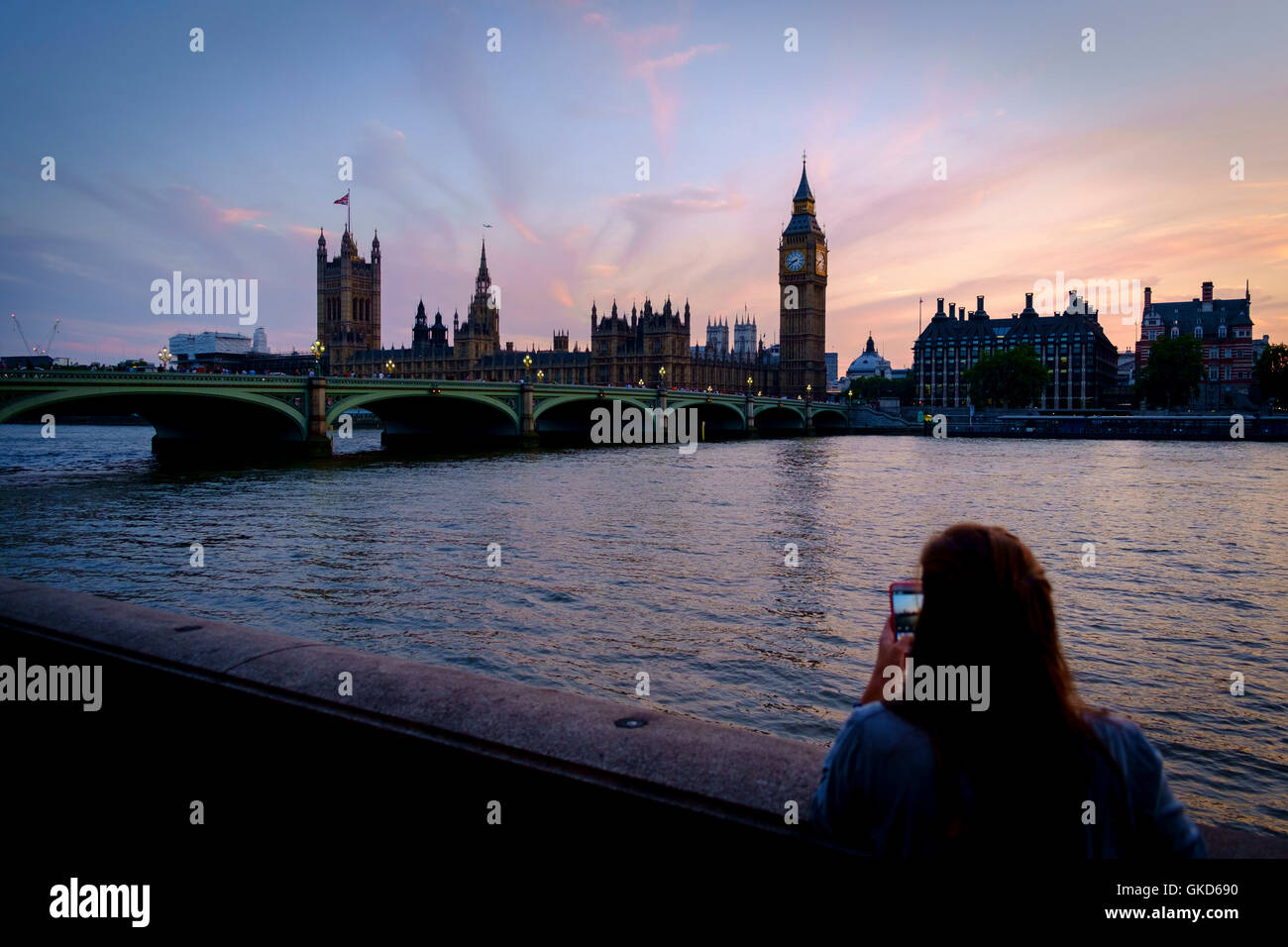 Rear view of unrecognizable tourist taking photo of beautiful cityscape ...