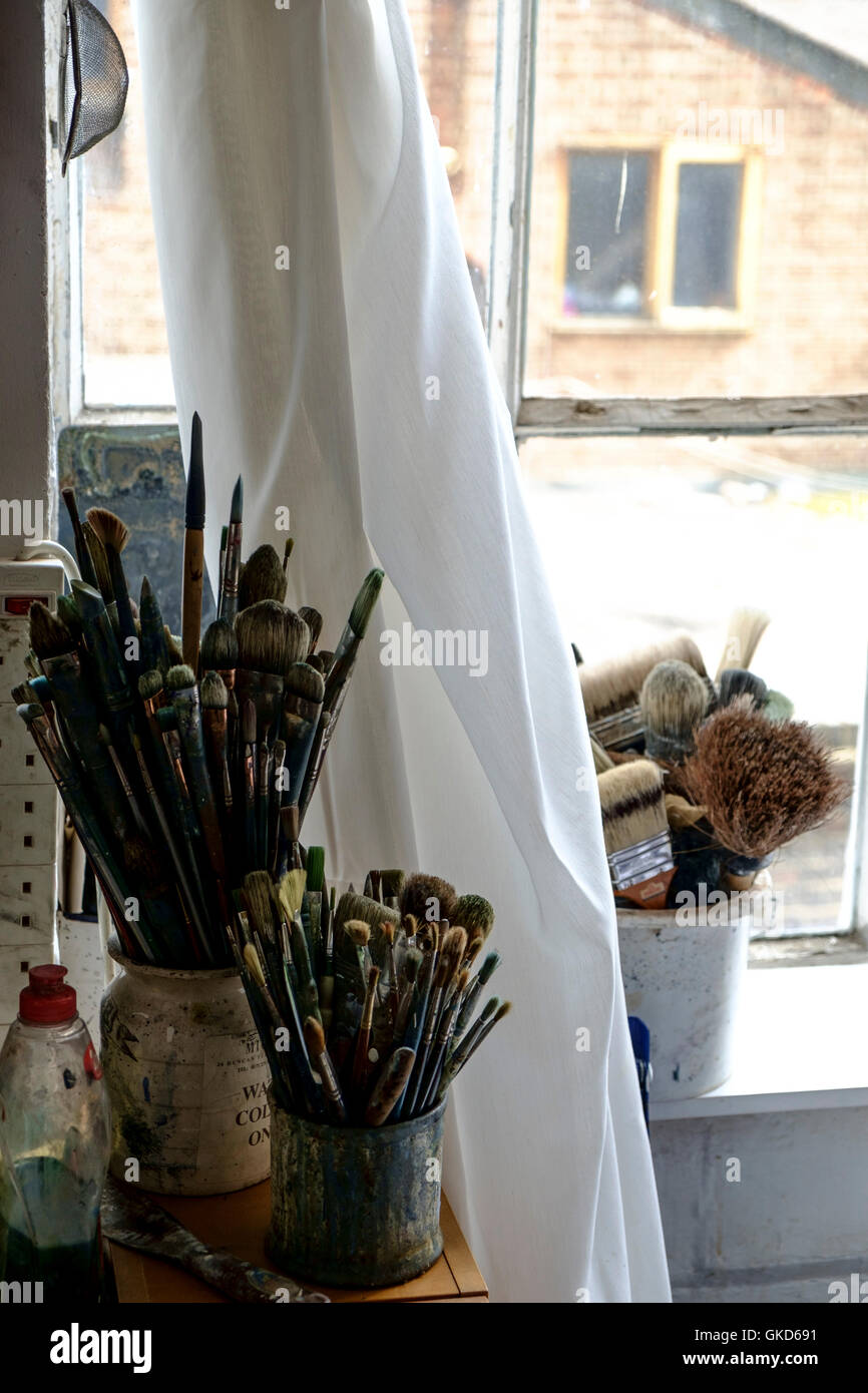 Still life of arranged washed paint brushes on window-sill in daylight ...