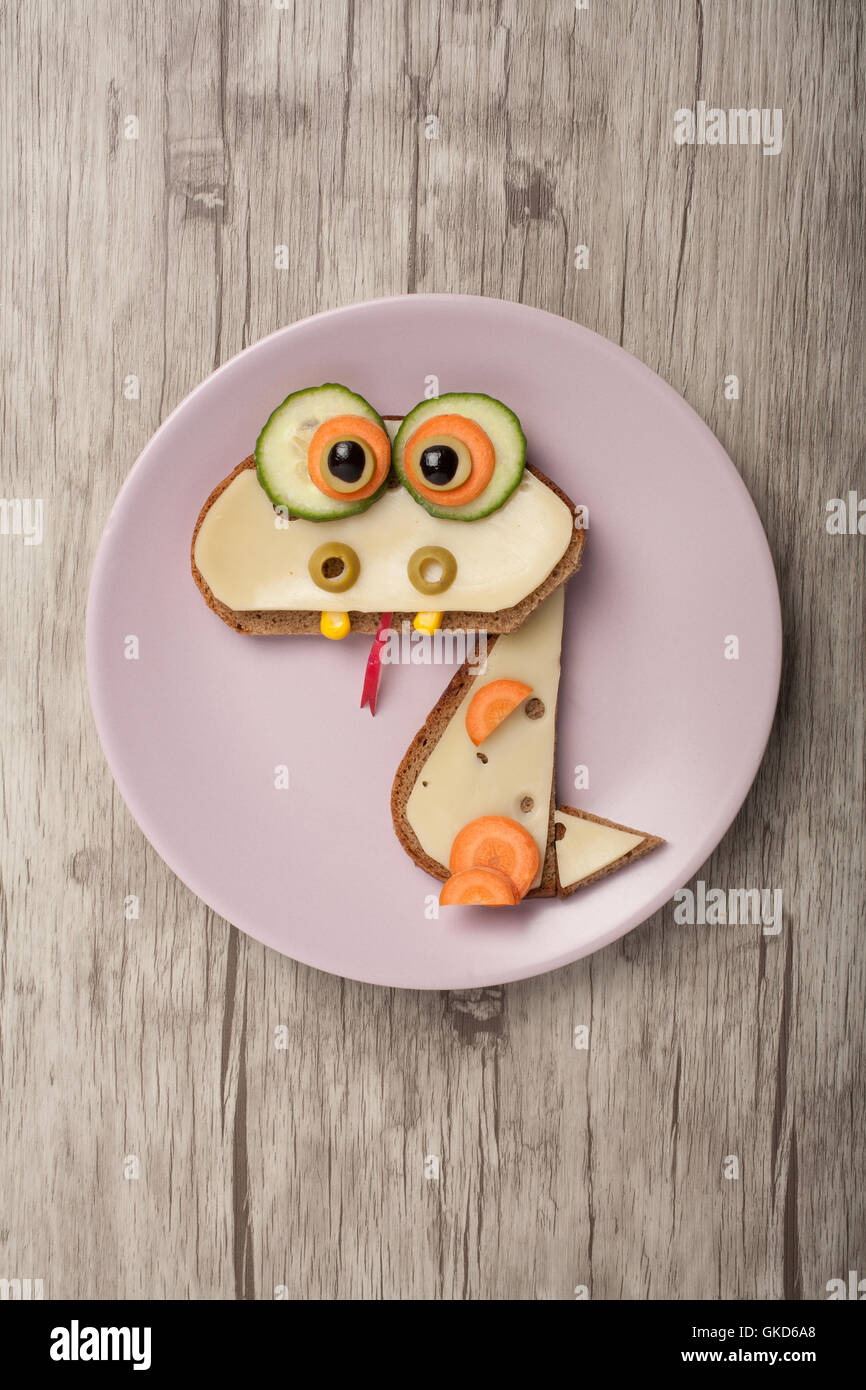Dragon made of bread and cheese on plate and desk Stock Photo - Alamy