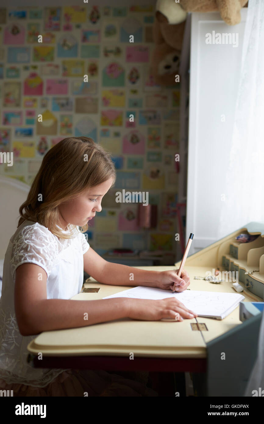 Young Girl Sitting At Desk And Writing In Bedroom Stock Photo - Alamy