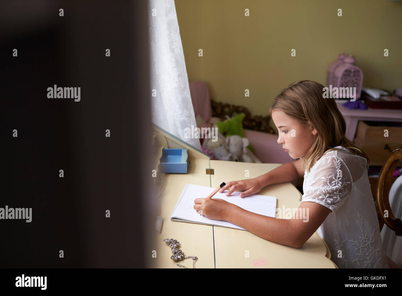 Young Girl Sitting At Desk And Writing In Bedroom Stock Photo - Alamy