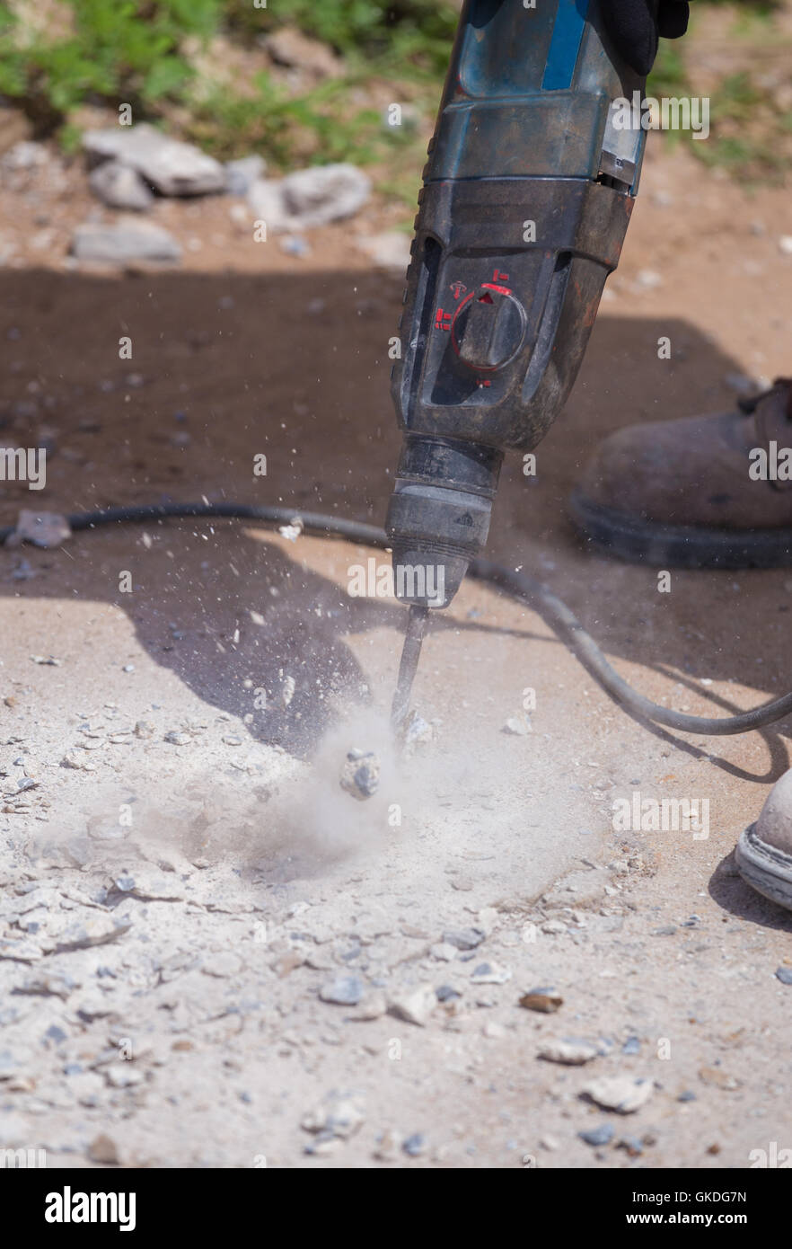 Worker repairing and drilling the concrete road Stock Photo - Alamy