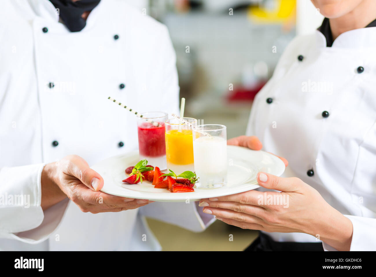 team of chefs with dessert in kitchen Stock Photo - Alamy
