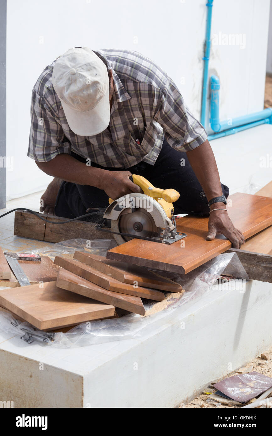 carpenter use electric saw to sawing wood board Stock Photo - Alamy