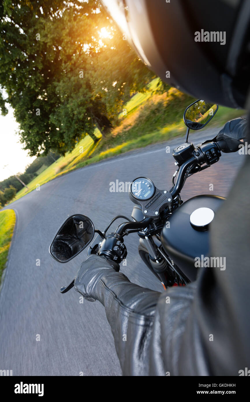 Motorcycle driver riding on motorway in beautiful sunset light. Shot ...