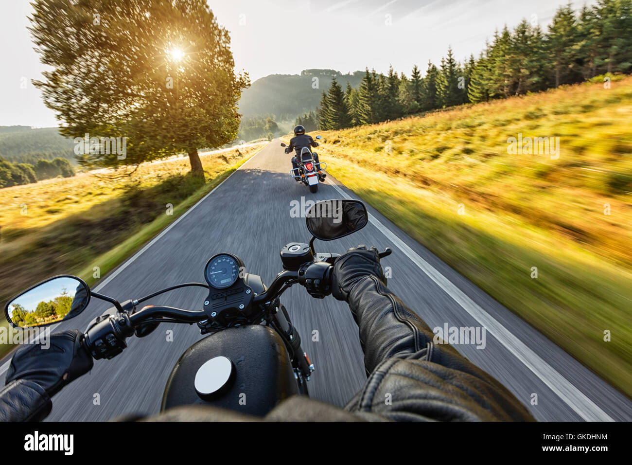 Motorcycle drivers riding on motorway in beautiful sunset light. Shot ...