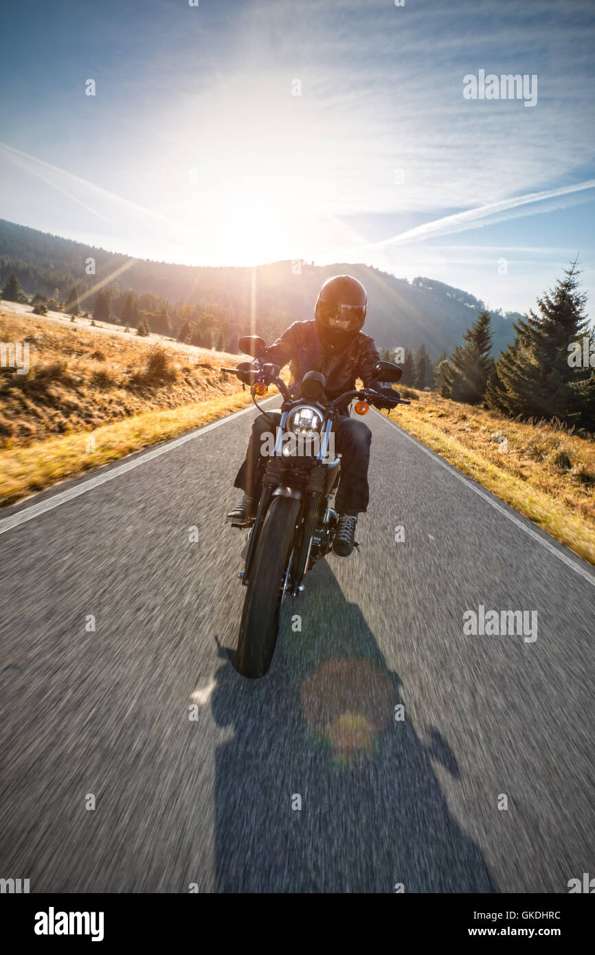 Motorcycle driver riding on motorway in beautiful sunset light. Shot ...