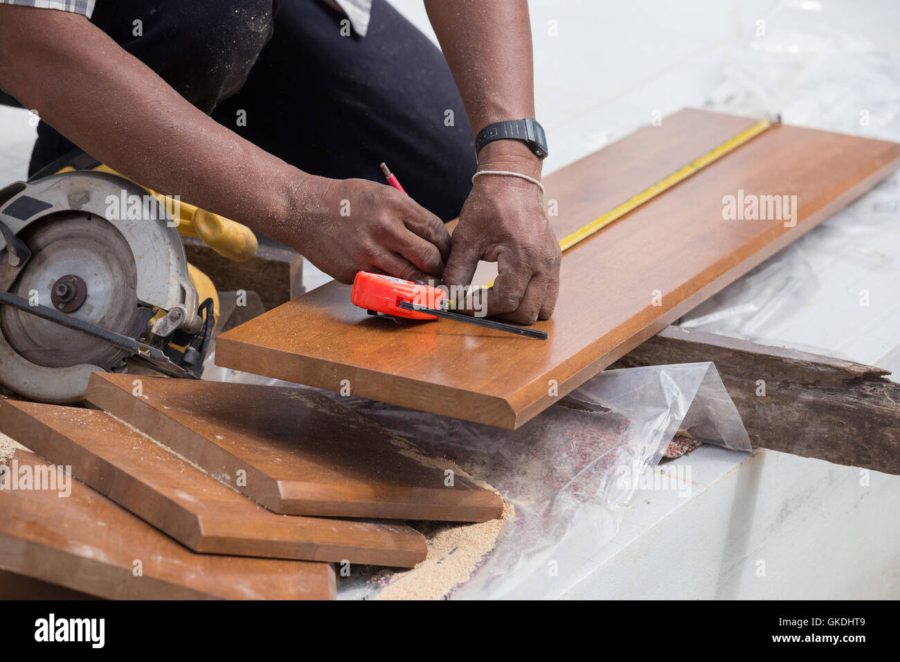 carpenter use Measure tape to measuring wood board Stock Photo - Alamy