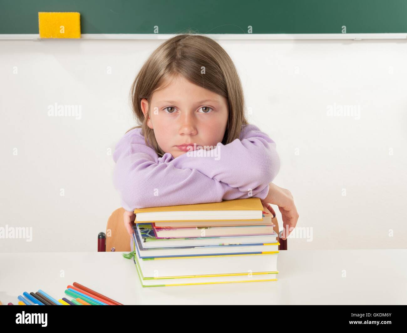 schoolgirl leaning on a pile of books Stock Photo - Alamy