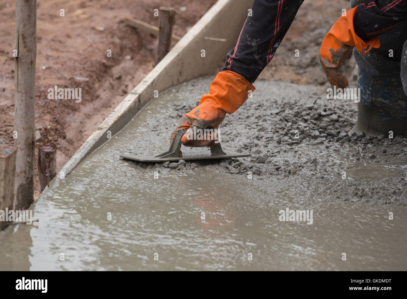 hand of builder worker use trowel plastering a newly poured concrete ...