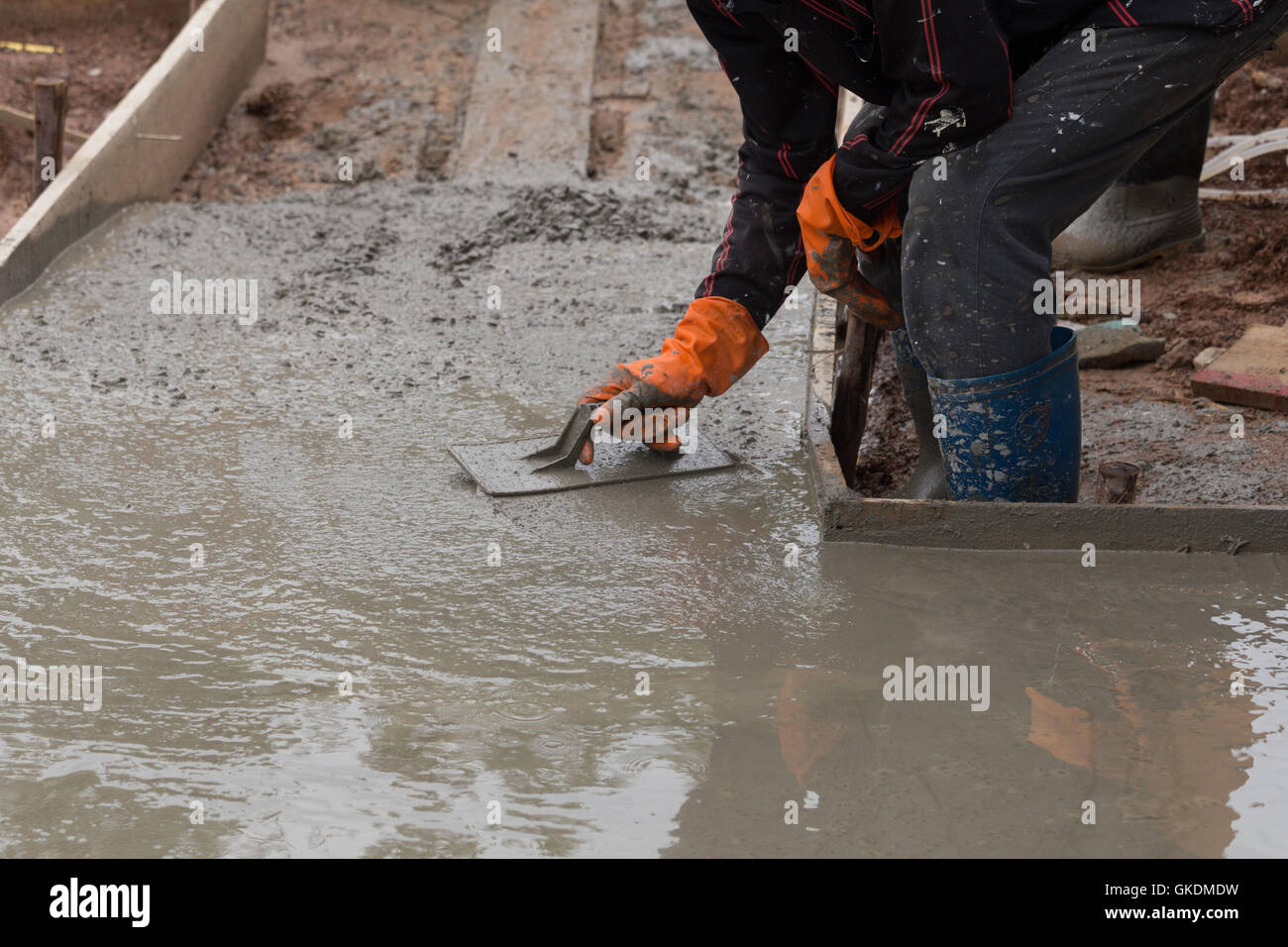 hand of builder worker use trowel plastering a newly poured concrete ...
