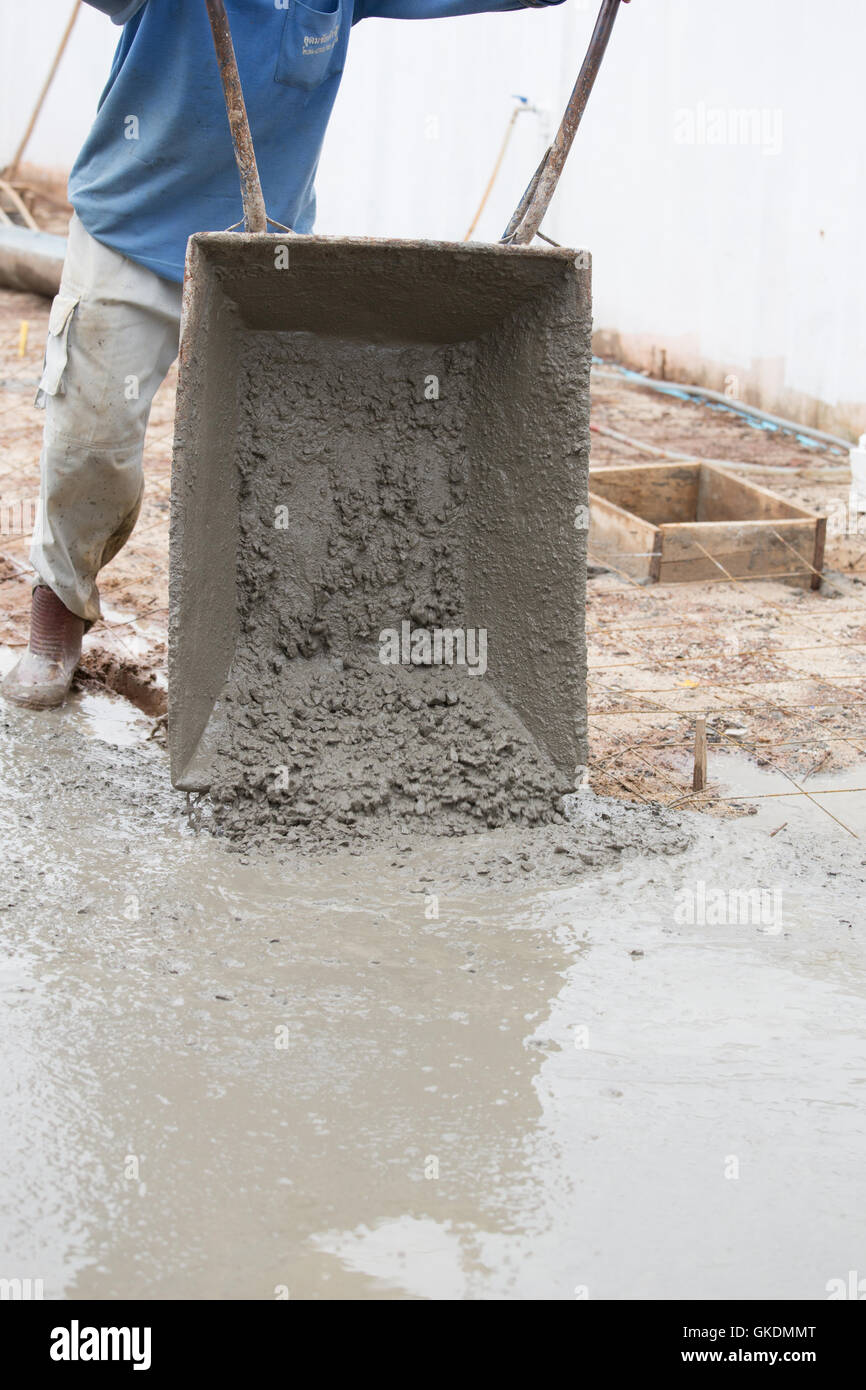 worker pouring cement from cart to floor at construction site Stock ...