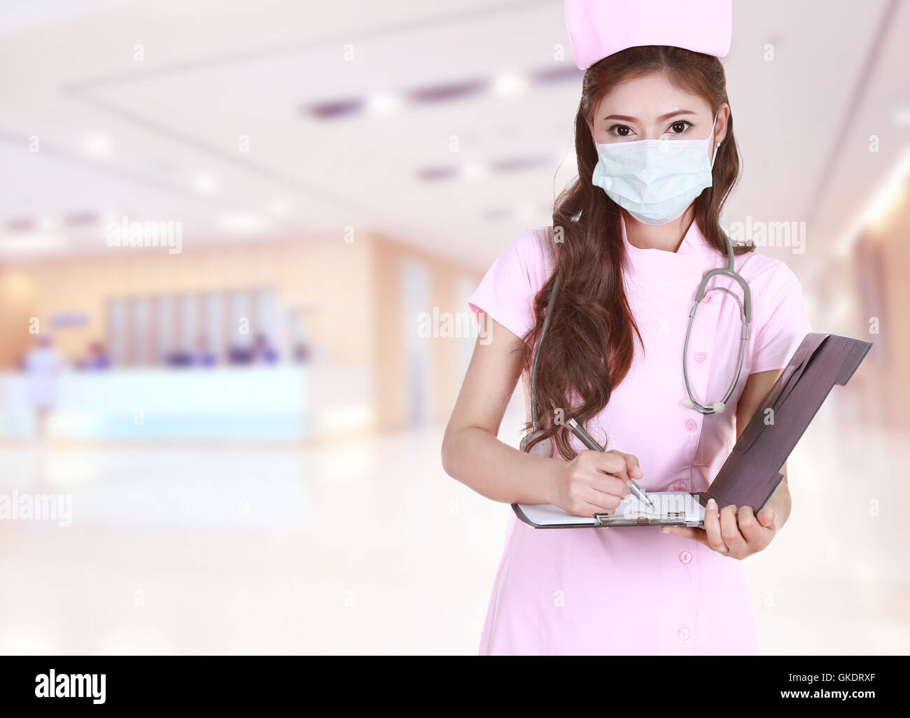 female nurse writing medical report in hospital background Stock Photo ...