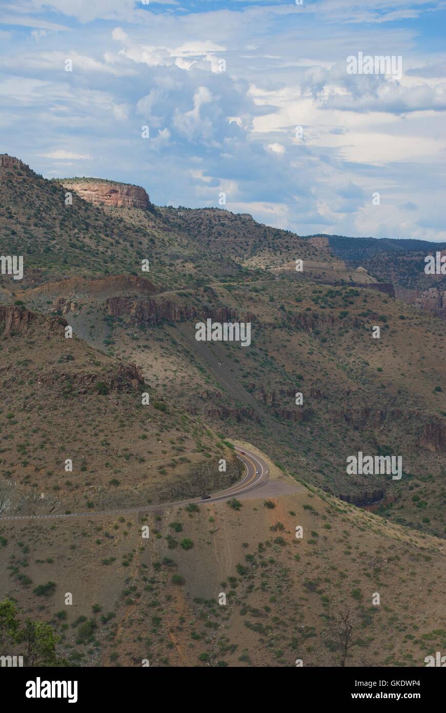 Huge Desert Cliffs looming over winding highway road Stock Photo - Alamy