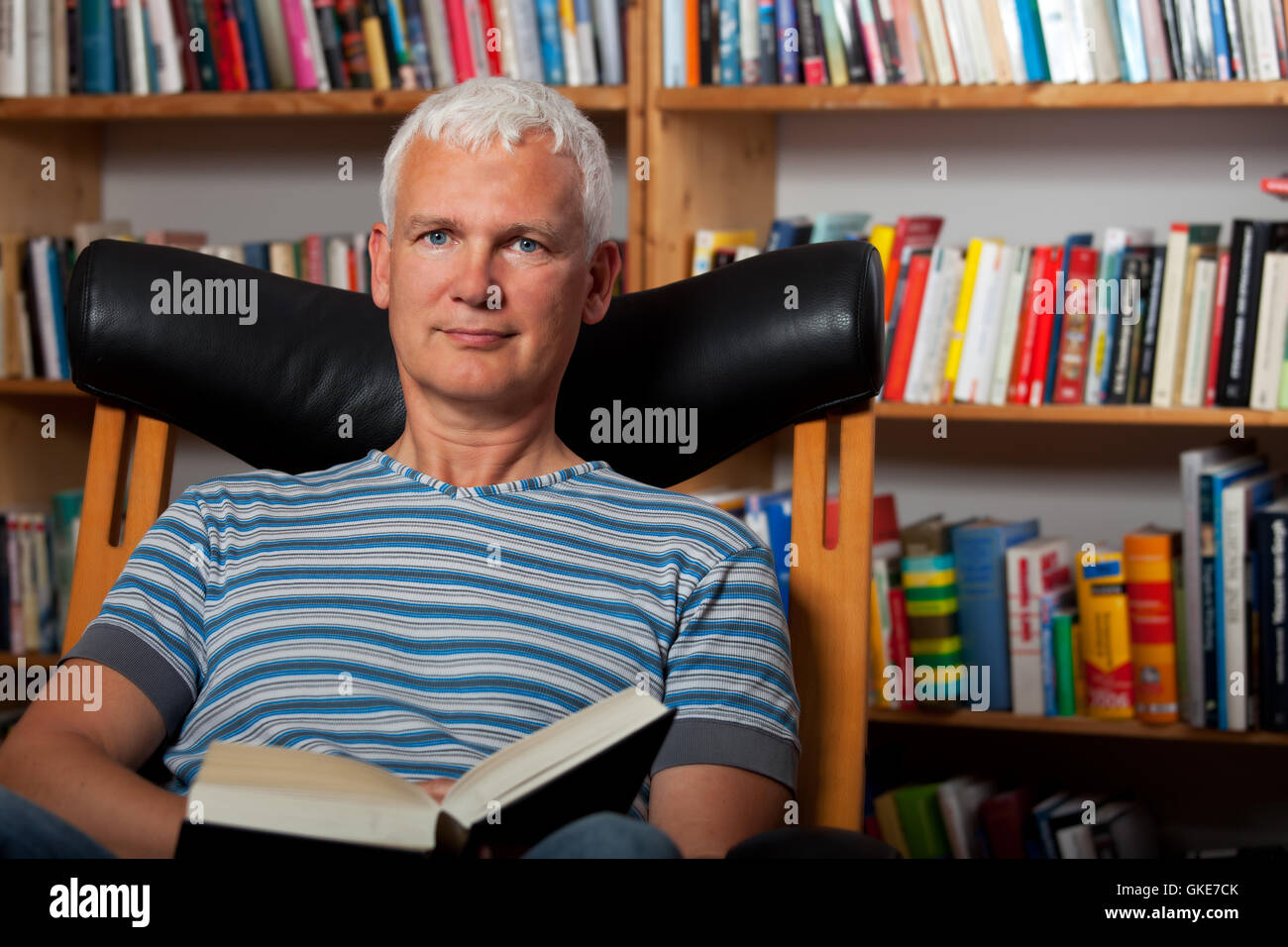 handsome man reading in a chair Stock Photo - Alamy