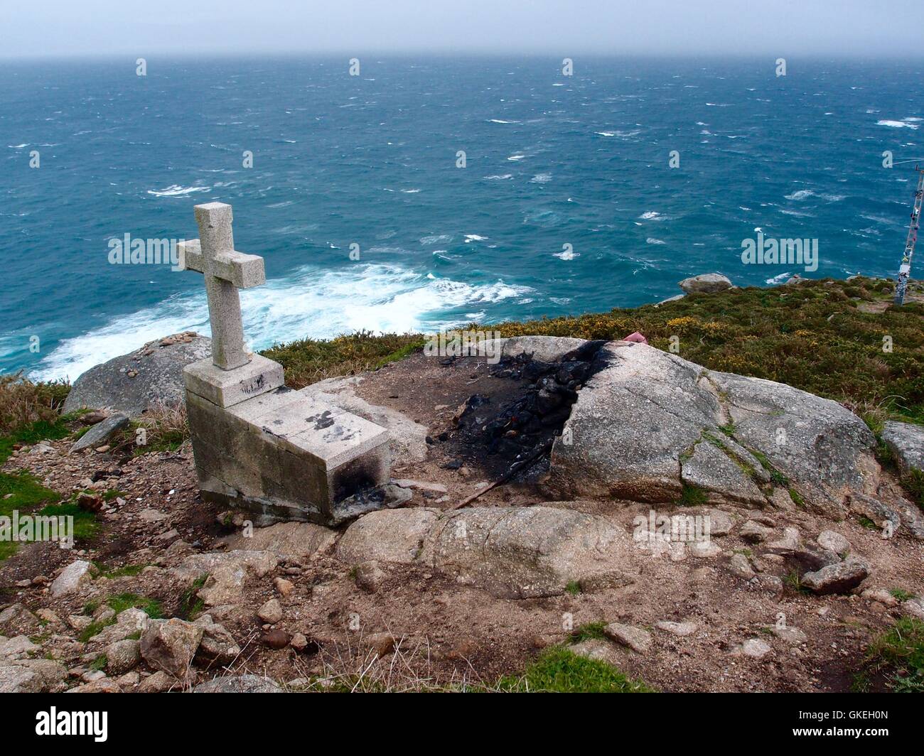 Cape with stone structure holding a stone cross, large stone with soot ...
