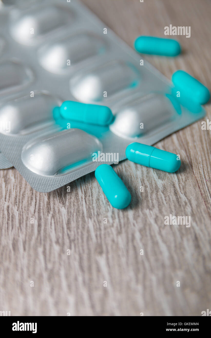 Blue medication, pills and blister pack from above on grey wooden ...