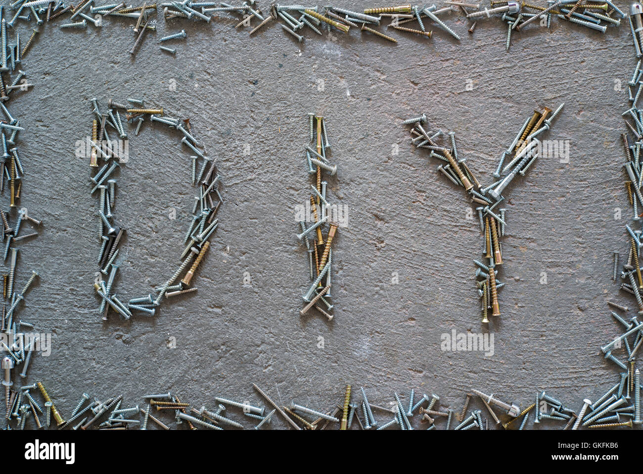 DIY word composed of screws and bolts on a cement surface. Top view ...