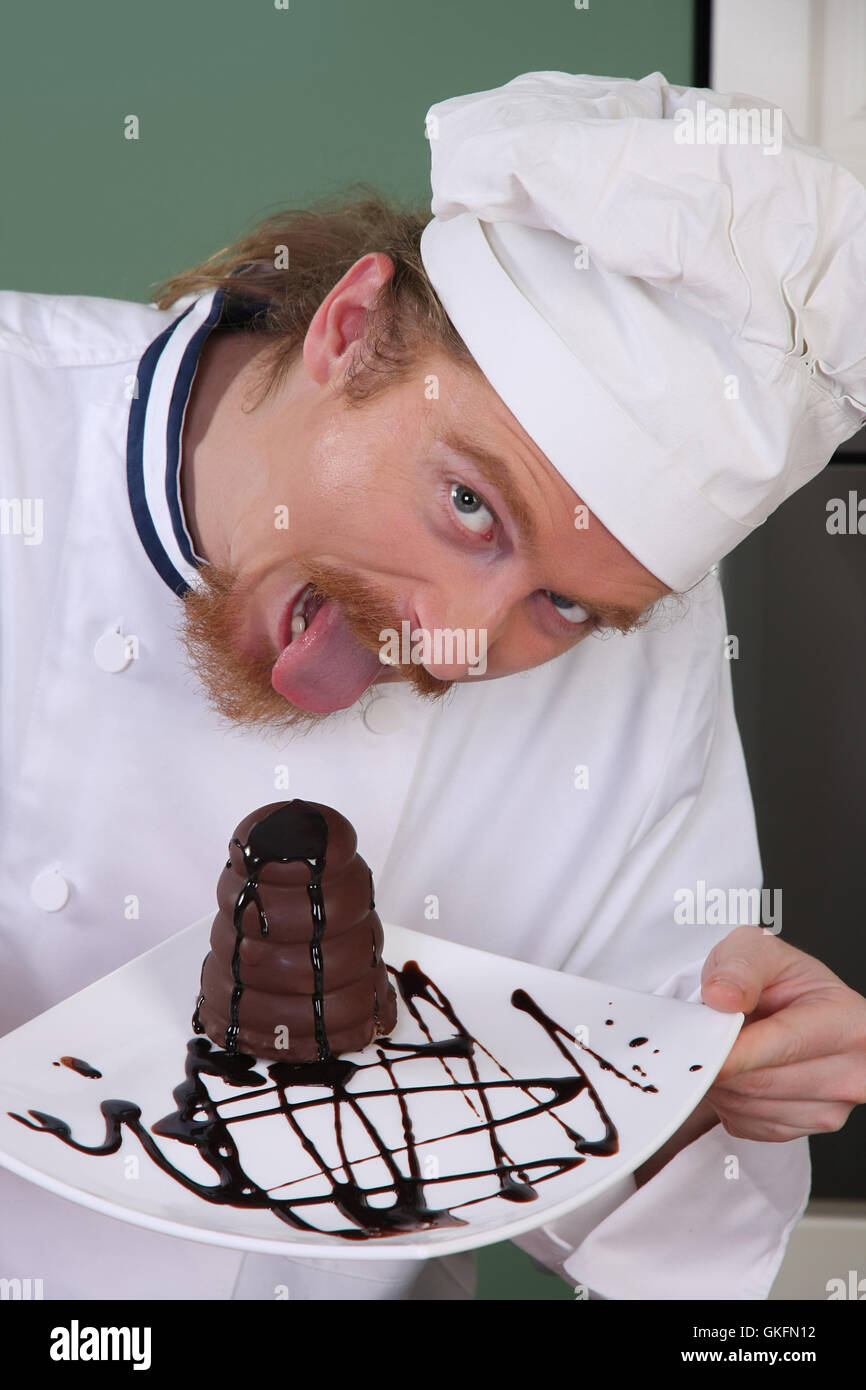 Funny young chef eating a piece of cake Stock Photo - Alamy