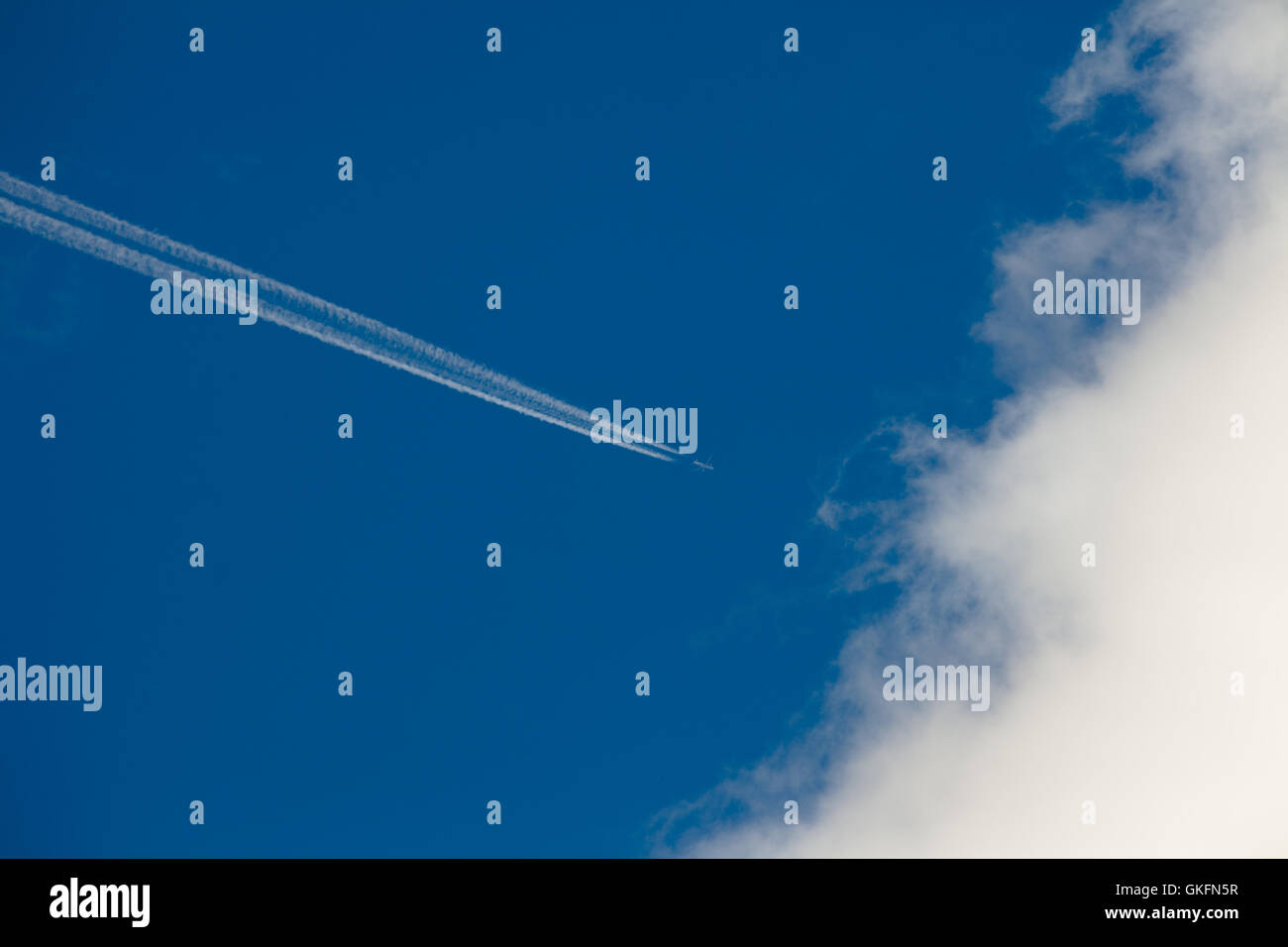 Airplane, condensation path, and cloud Stock Photo - Alamy