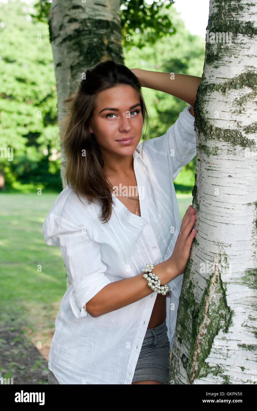 Cute girl standing near the birches Stock Photo - Alamy
