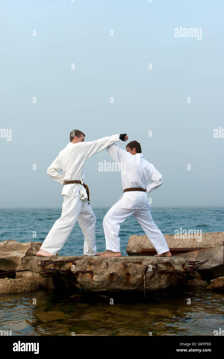 two karateka fight on the banks of the misty sea Stock Photo - Alamy