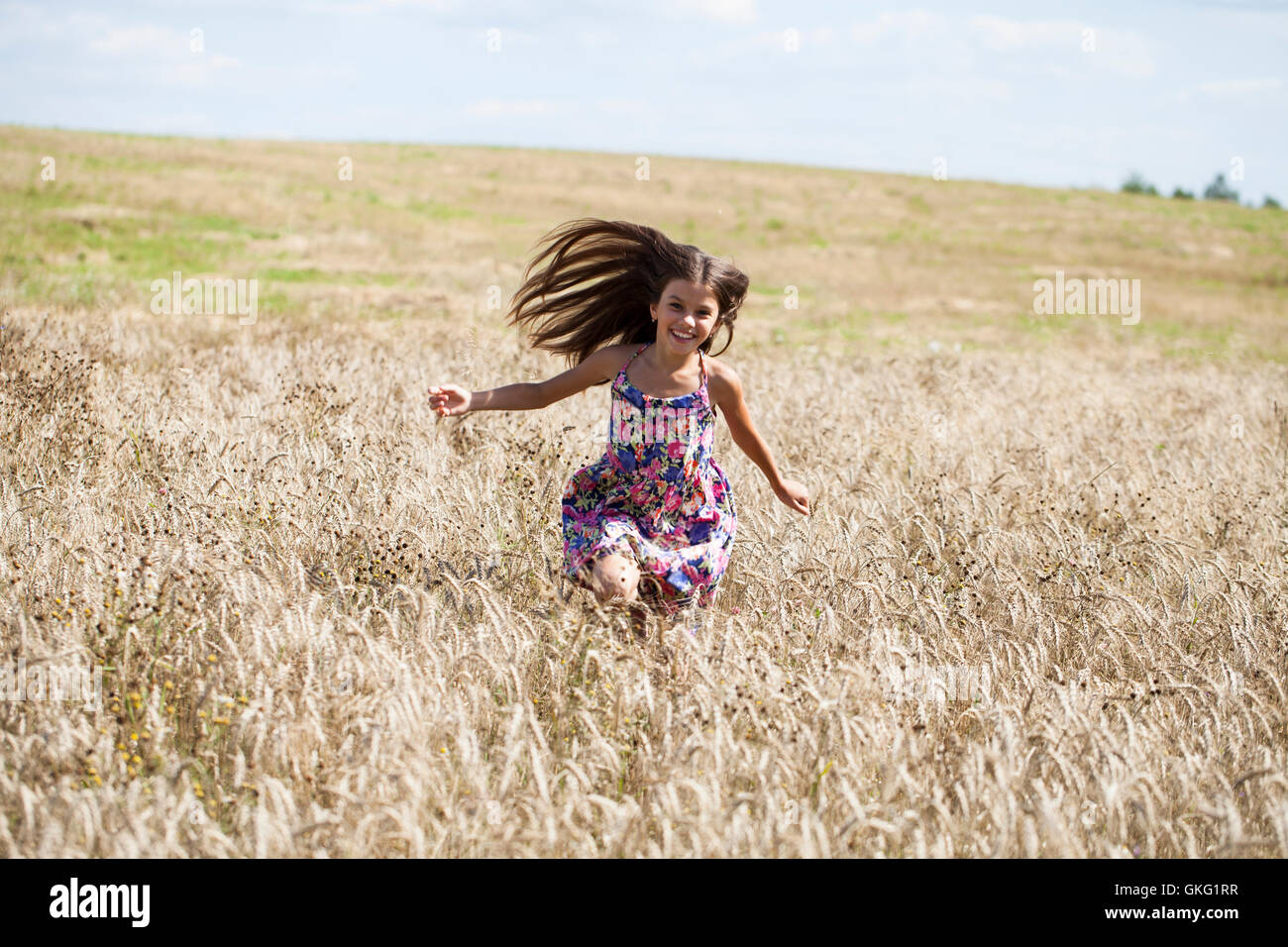 Happy little girl running in summer field Stock Photo - Alamy