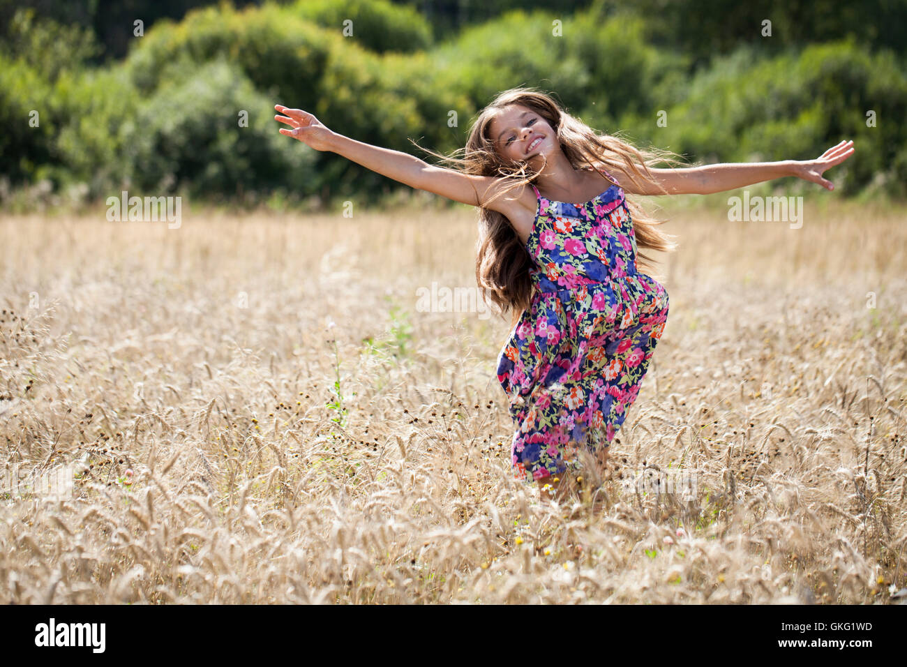 Happy little girl running in summer field Stock Photo - Alamy