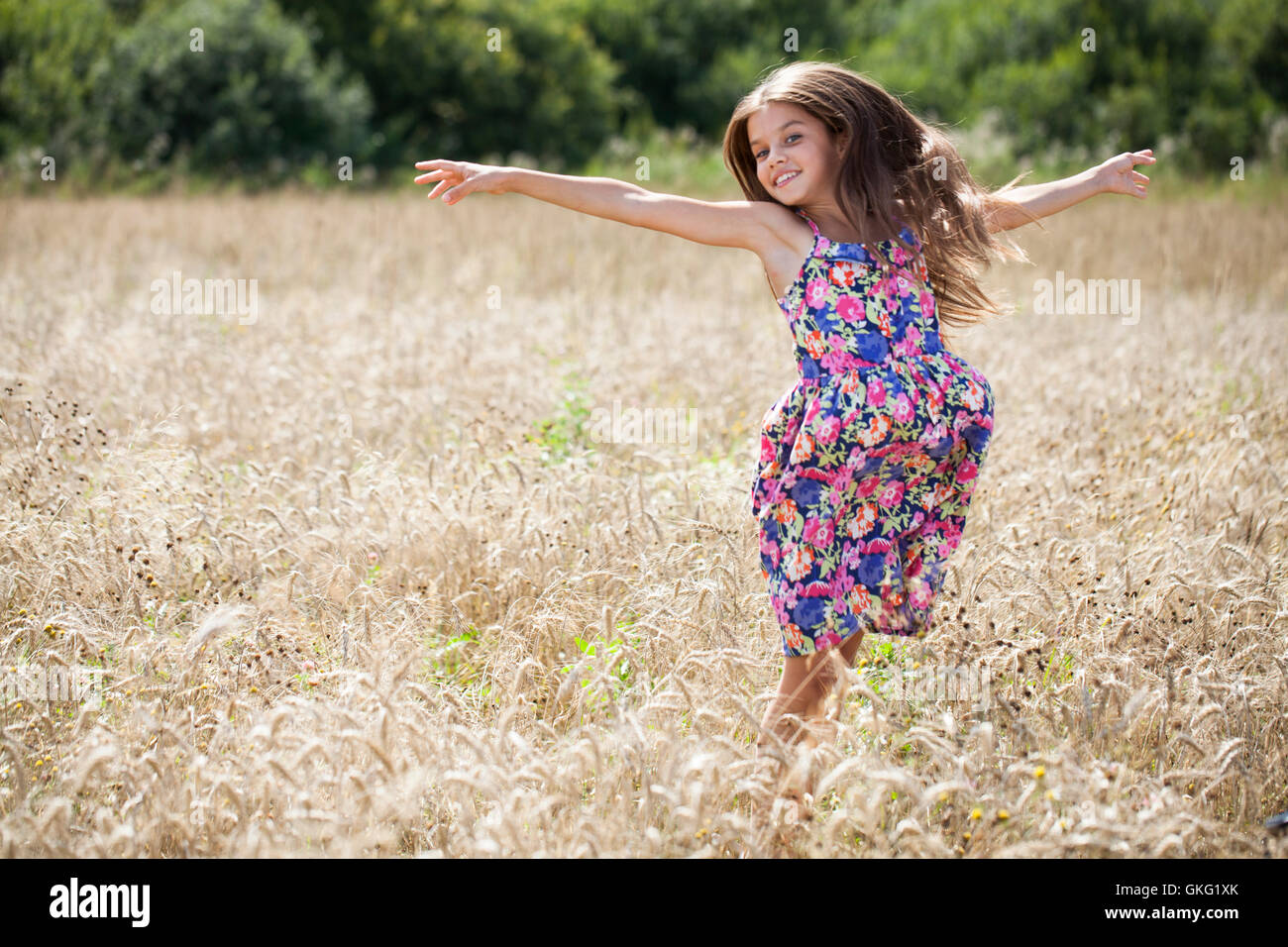 Happy little girl running in summer field Stock Photo - Alamy