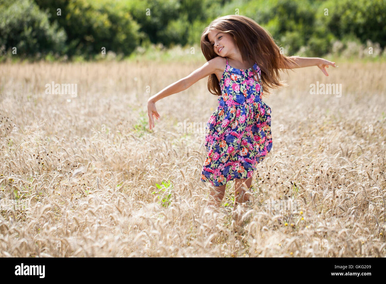 Happy little girl running in summer field Stock Photo - Alamy