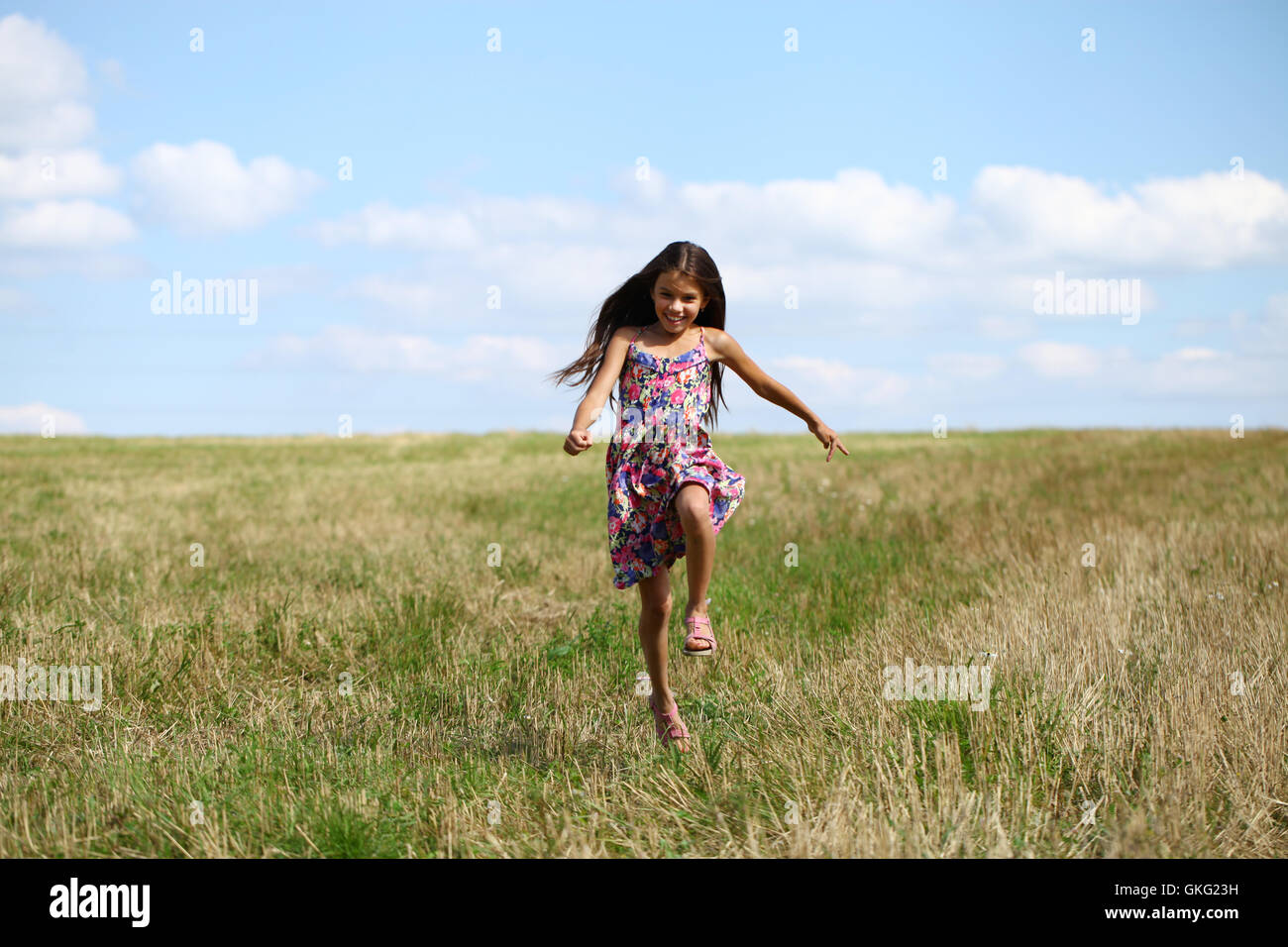 Happy little girl running in summer field Stock Photo - Alamy