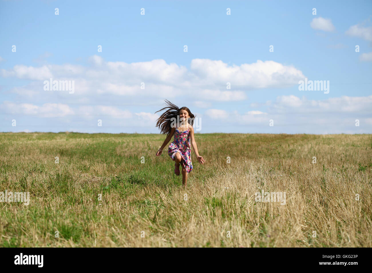 Happy little girl running in summer field Stock Photo - Alamy